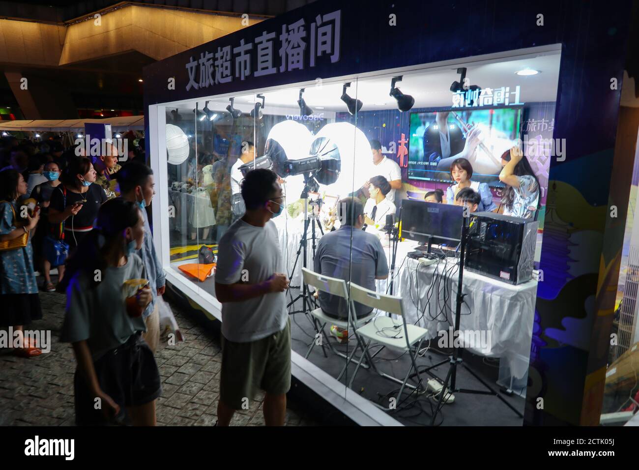 People walk around and shop at the "2020 Amazing Night in Hangzhou", a ...