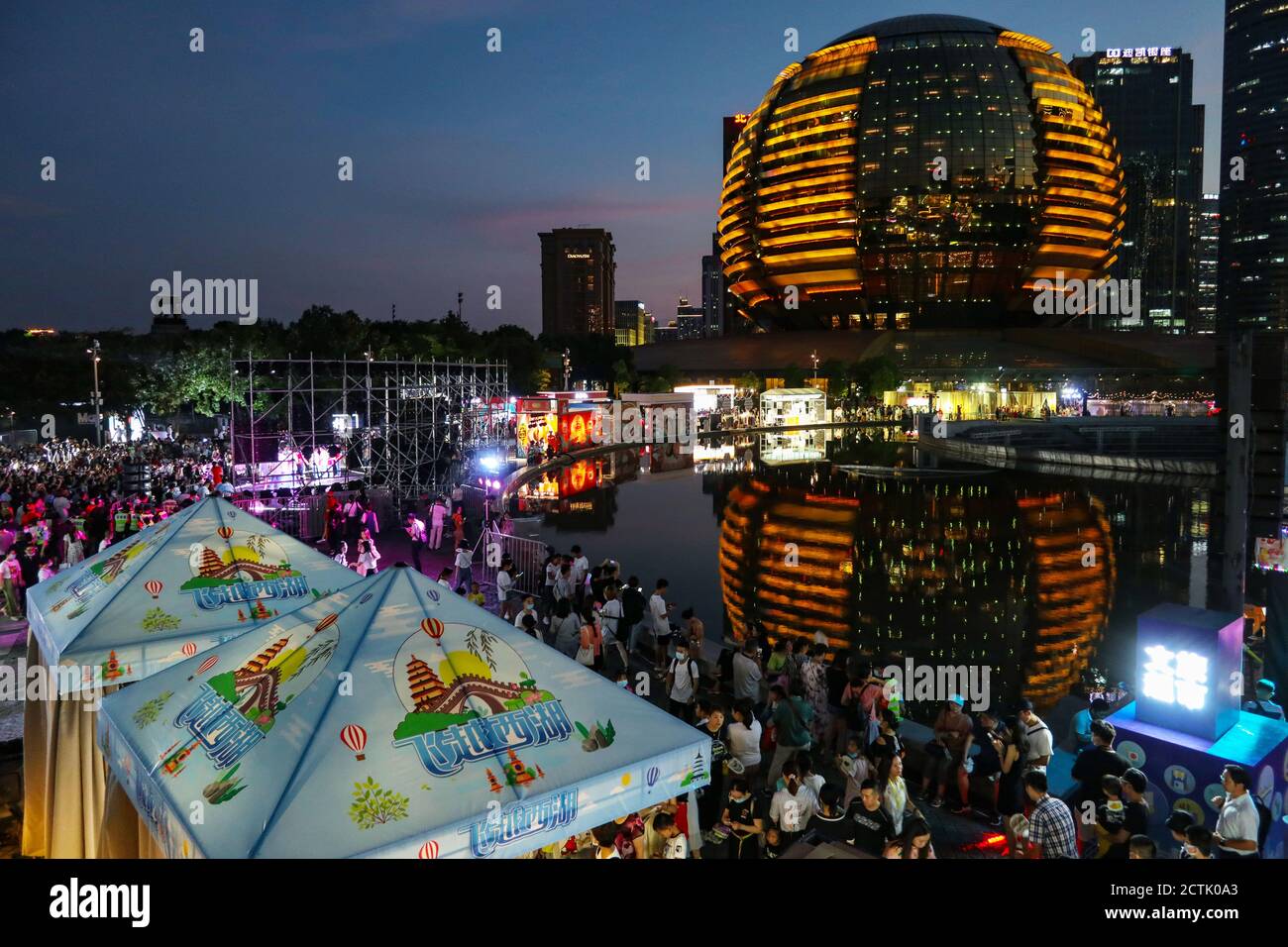 People walk around and shop at the "2020 Amazing Night in Hangzhou", a ...