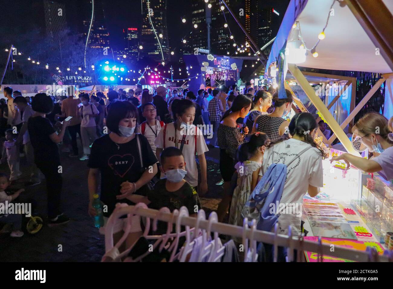 People walk around and shop at the "2020 Amazing Night in Hangzhou", a ...