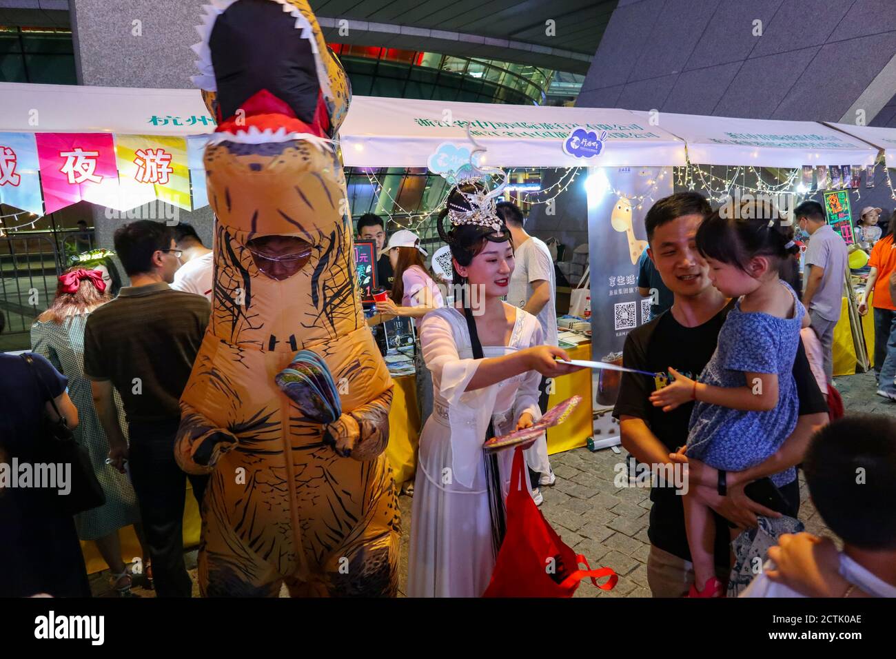 People walk around and shop at the "2020 Amazing Night in Hangzhou", a ...