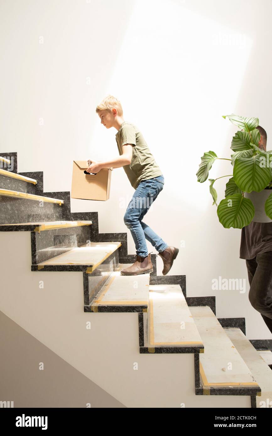 Man carrying box up steps hi-res stock photography and images - Alamy
