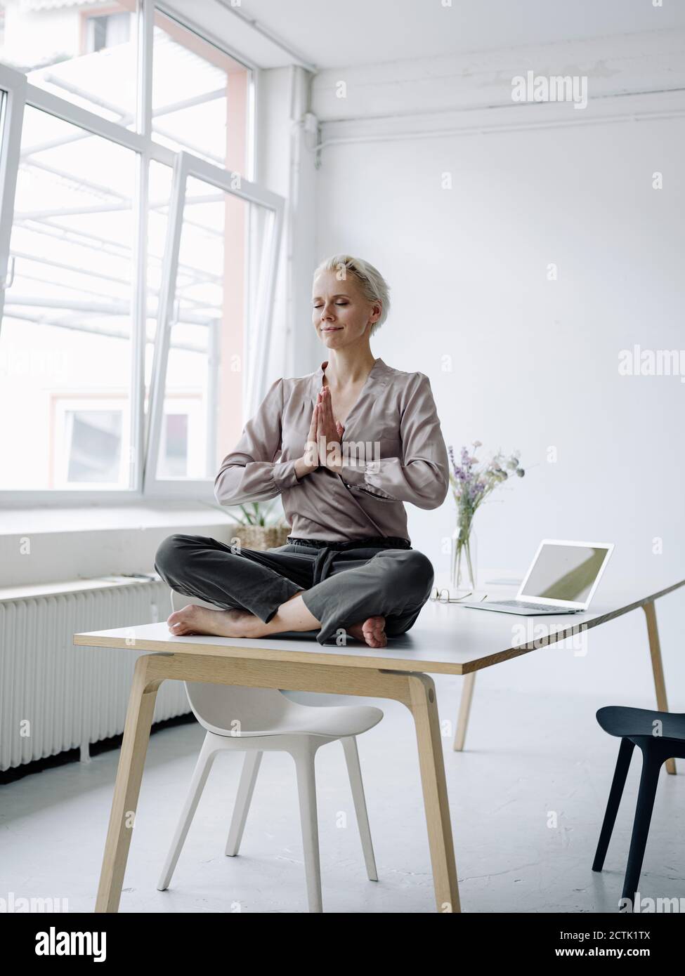 Business woman meditating on desk hi-res stock photography and images ...