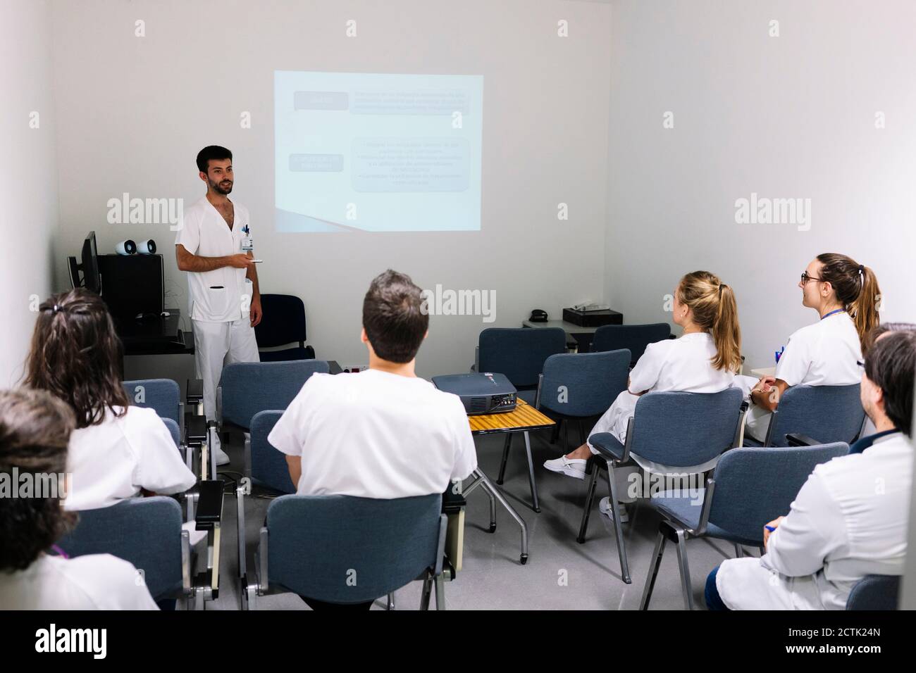 Doctor giving presentation to colleagues in board room at hospital ...