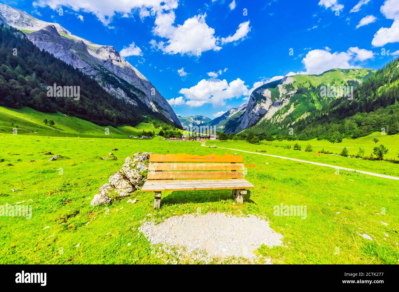 Austria, Tyrol, Vomp, Empty bench in Lower Inn Valley with village in ...