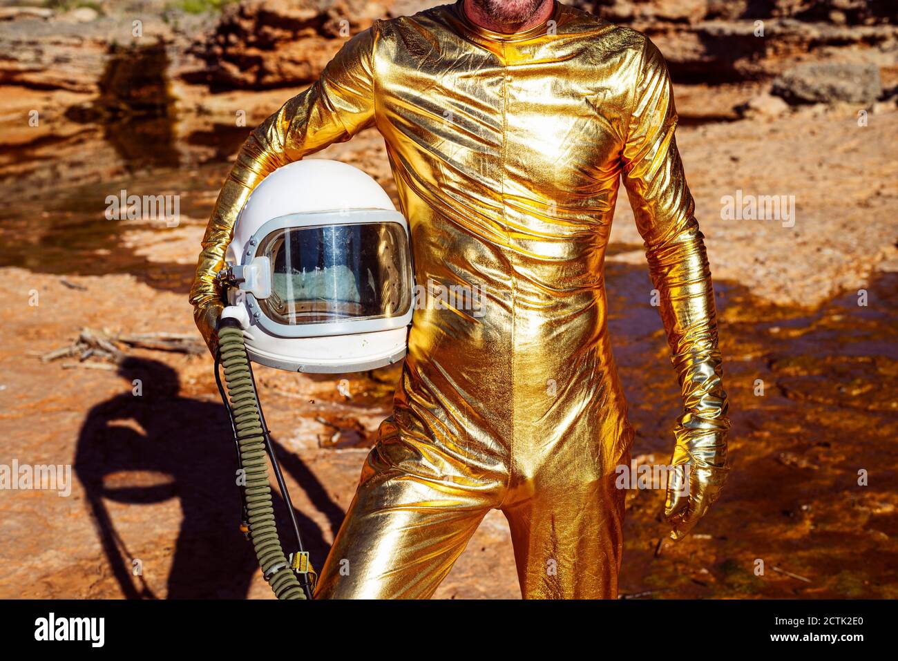 Close-up of astronaut holding space helmet near waist while standing on ...