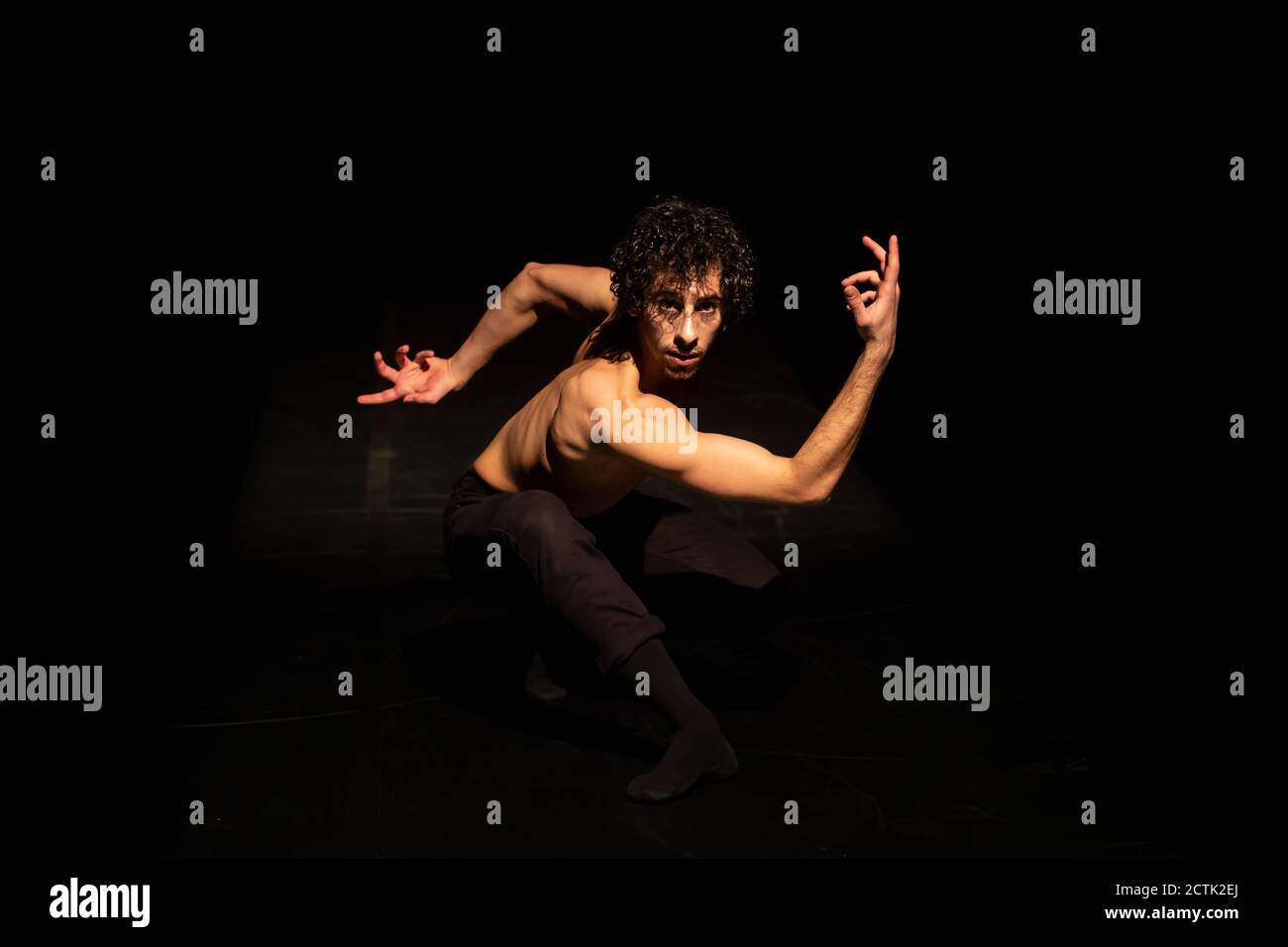Male ballet dancer performing on black stage Stock Photo - Alamy