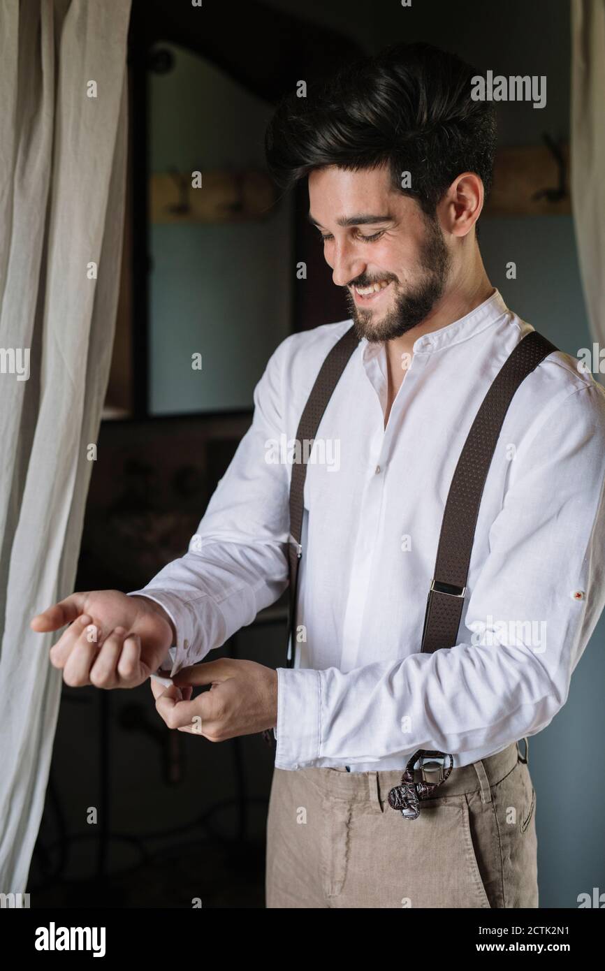 Happy groom getting ready while standing at dressing room Stock Photo ...