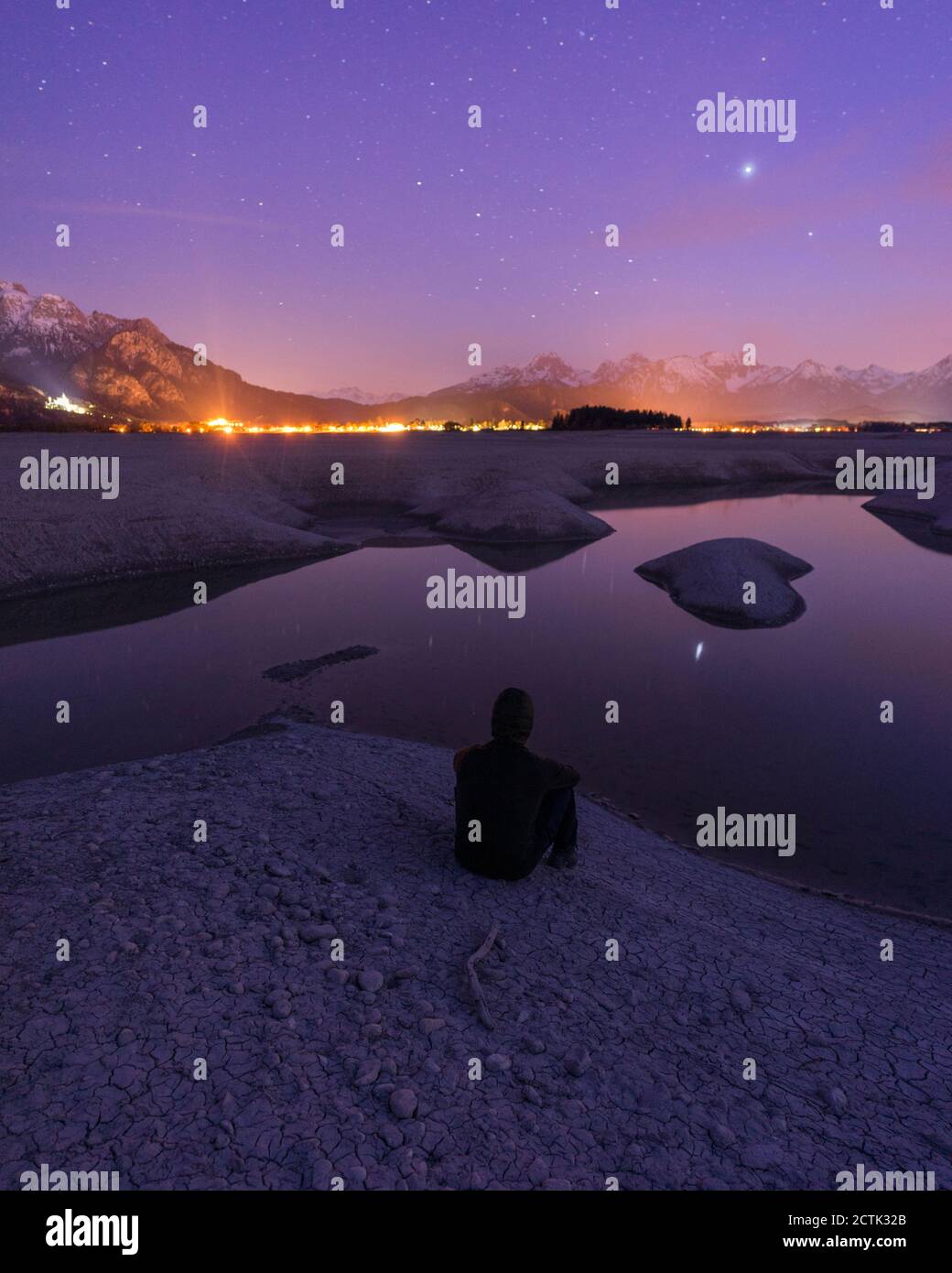 Germany, Bavaria, Silhouette of hooded man admiring Forggensee lake at ...