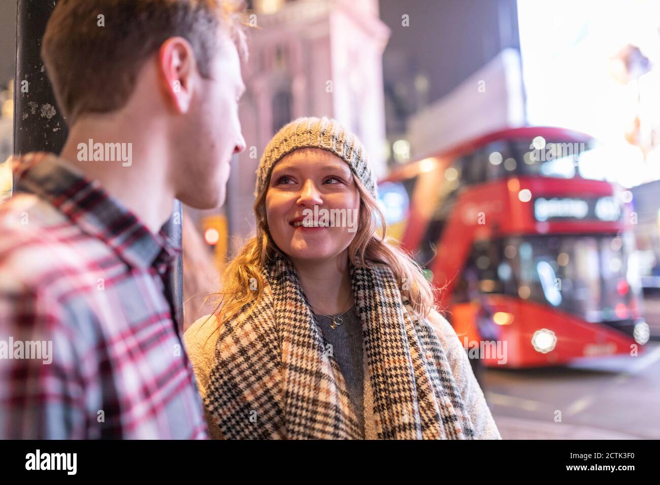 Young couple talking while standing at Piccadilly Circus with double ...
