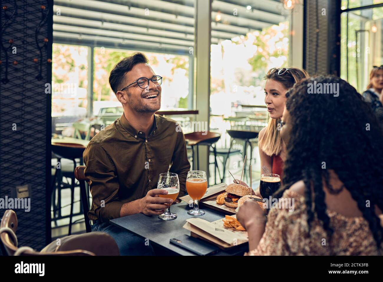 Happy friends socializing in a pub Stock Photo - Alamy