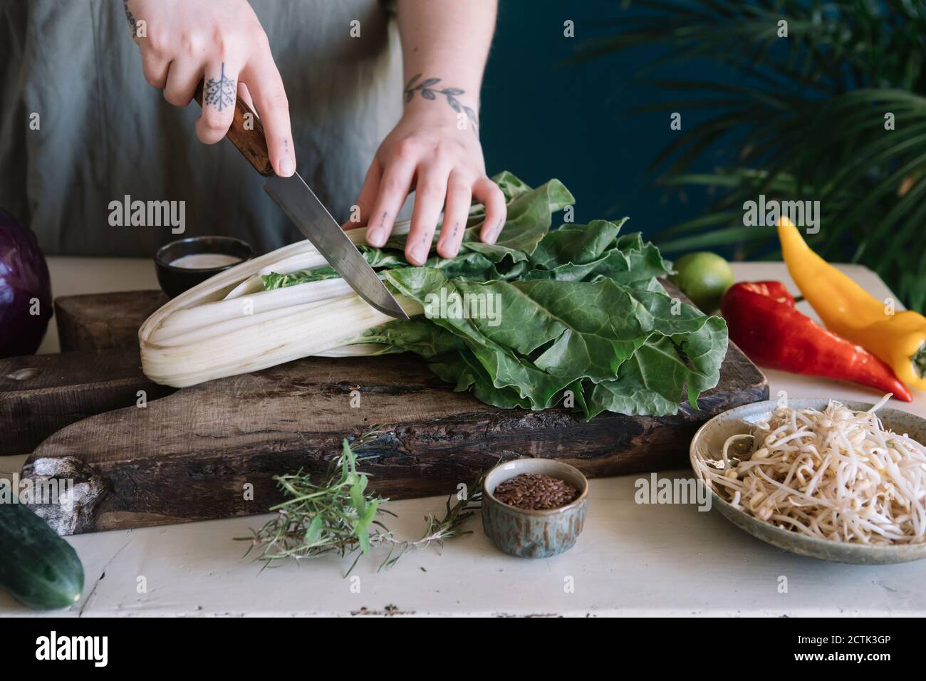 Young woman cutting pak choi on chopping board Stock Photo - Alamy