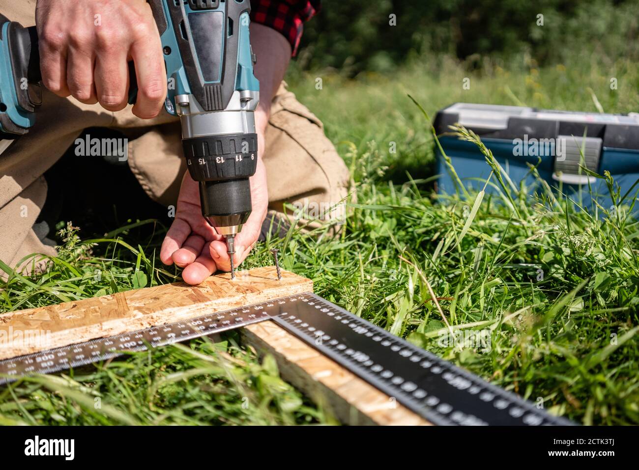 Carpenter drilling screws on plank during sunny day Stock Photo - Alamy