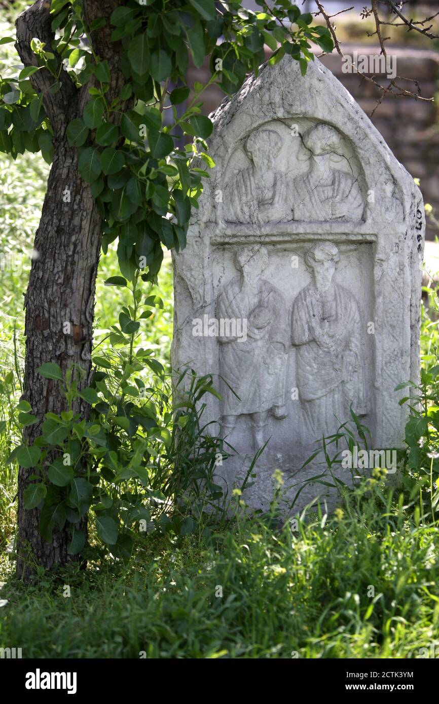 A Roman gravestone sitting adjacent to a tree at the ancient Roman Bath ...
