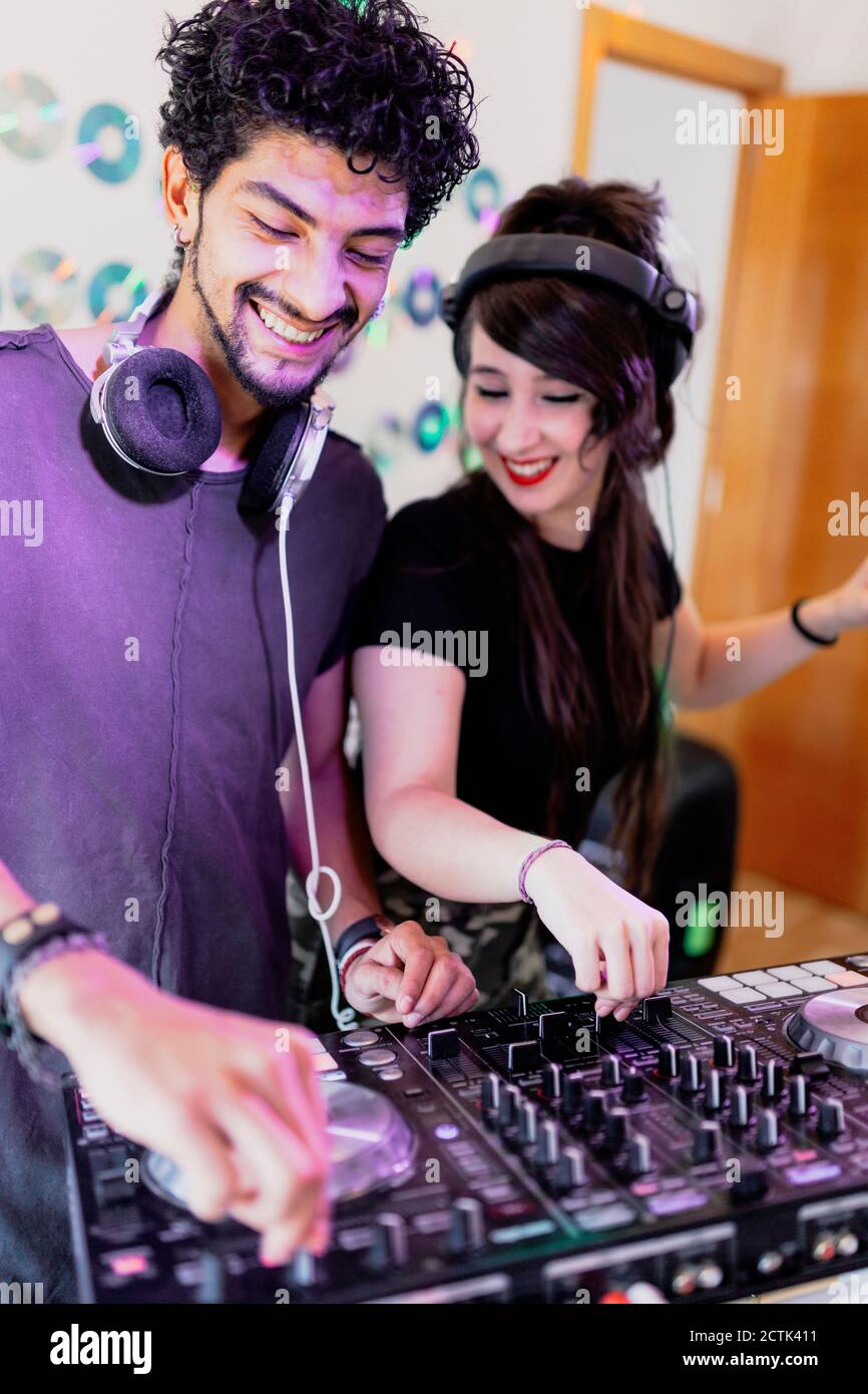 Happy DJing couple mixing sound together at recording studio Stock ...