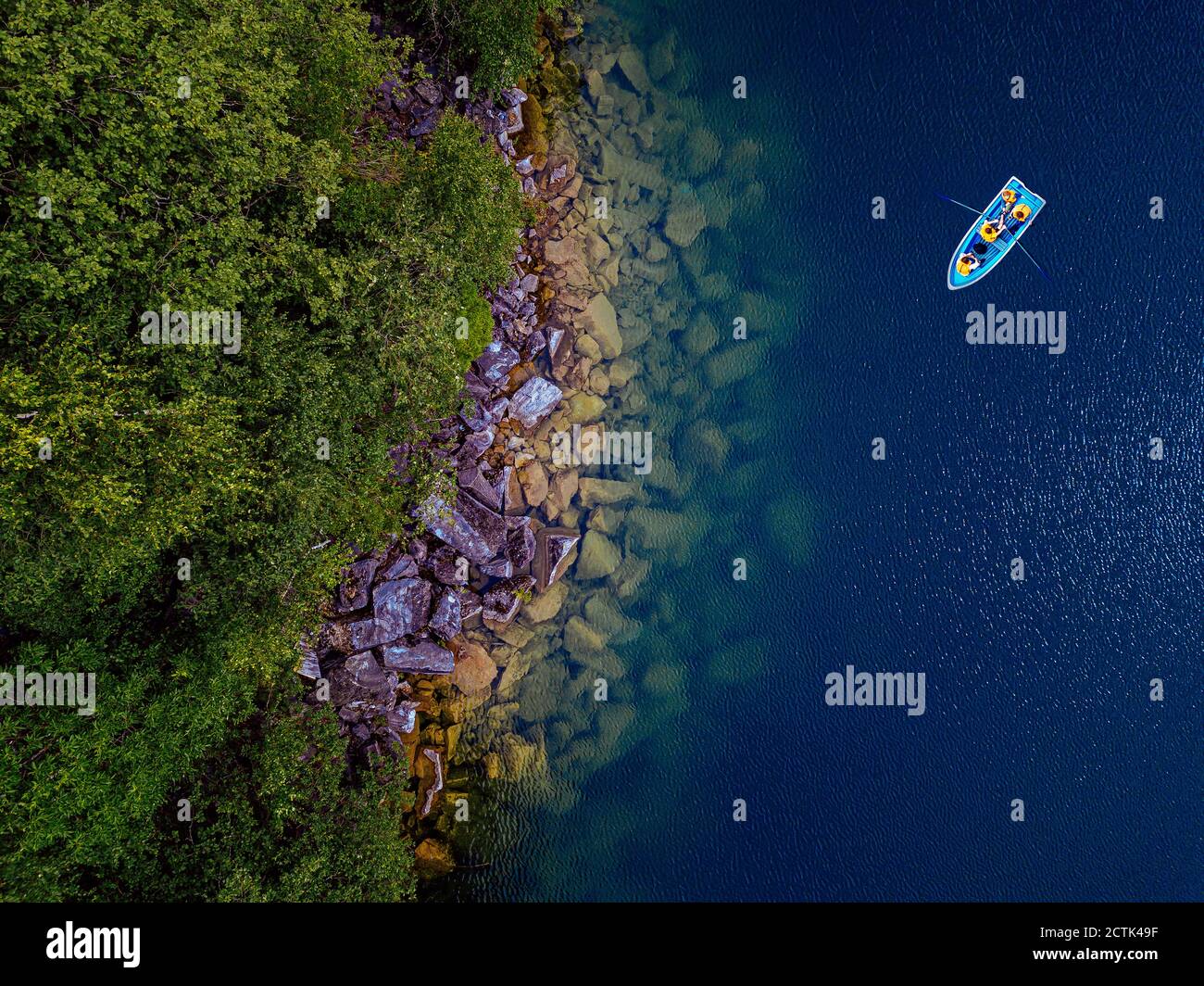 Aerial view of boat at rocky shore of Lake Light Stock Photo - Alamy