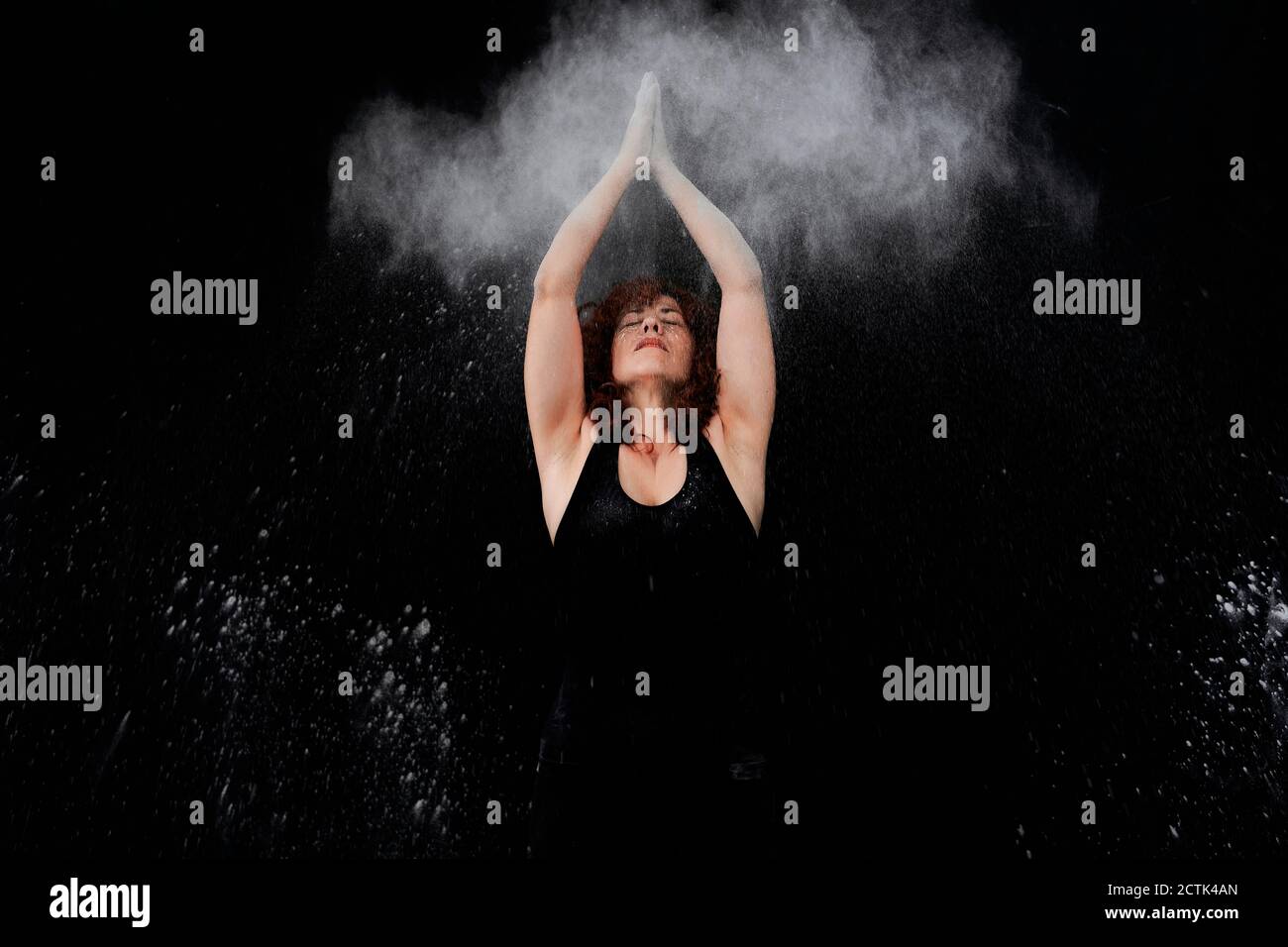 Woman clapping over head with white dust against black background Stock ...
