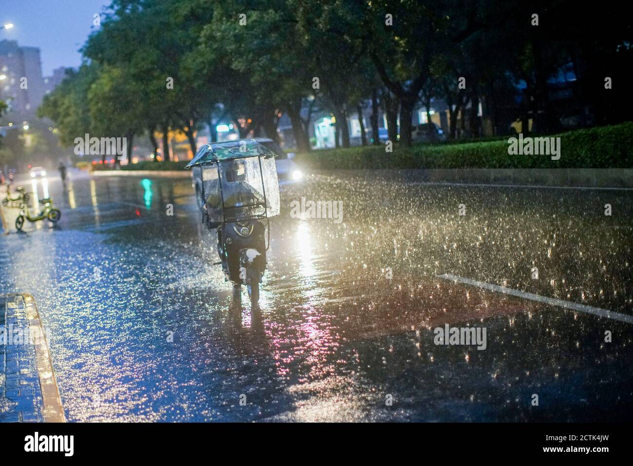 Motor, pedestrians and vehicles trek in the downpour, which might be ...