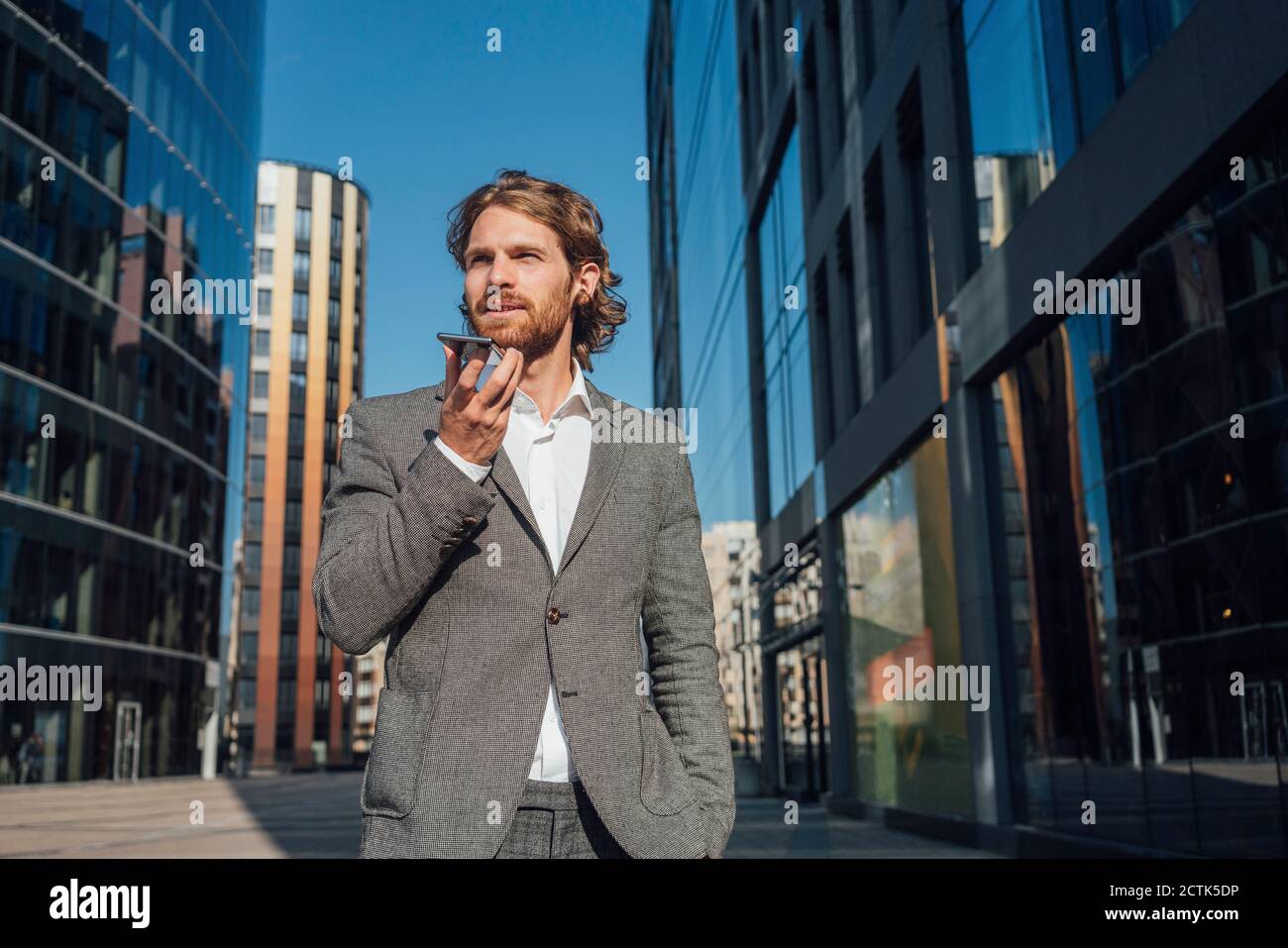 Confident handsome male professional talking on smart phone through ...
