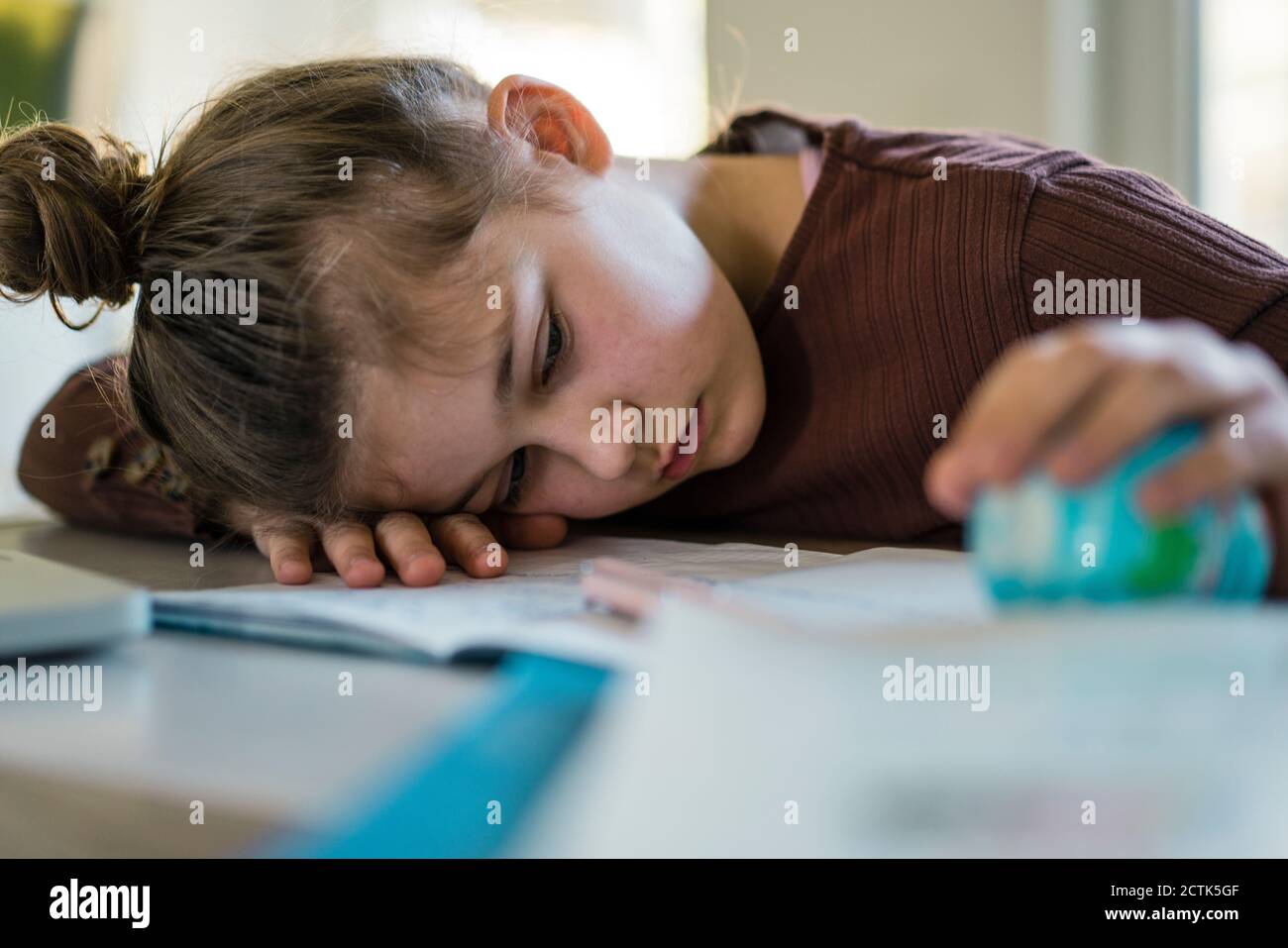 Sad girl with globe sleeping on study table Stock Photo - Alamy