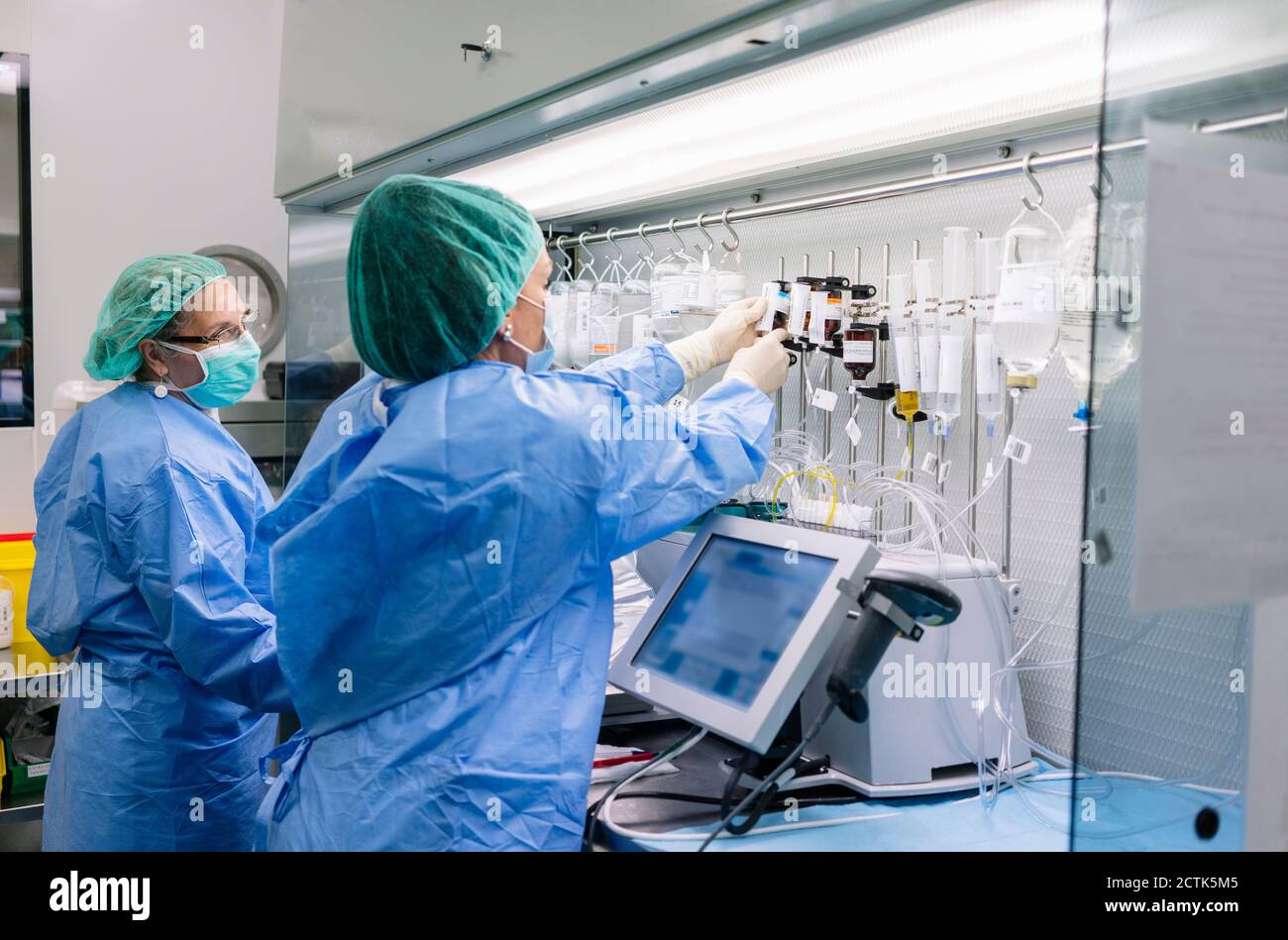 Female pharmacists arranging drips on rack at laboratory in hospital ...