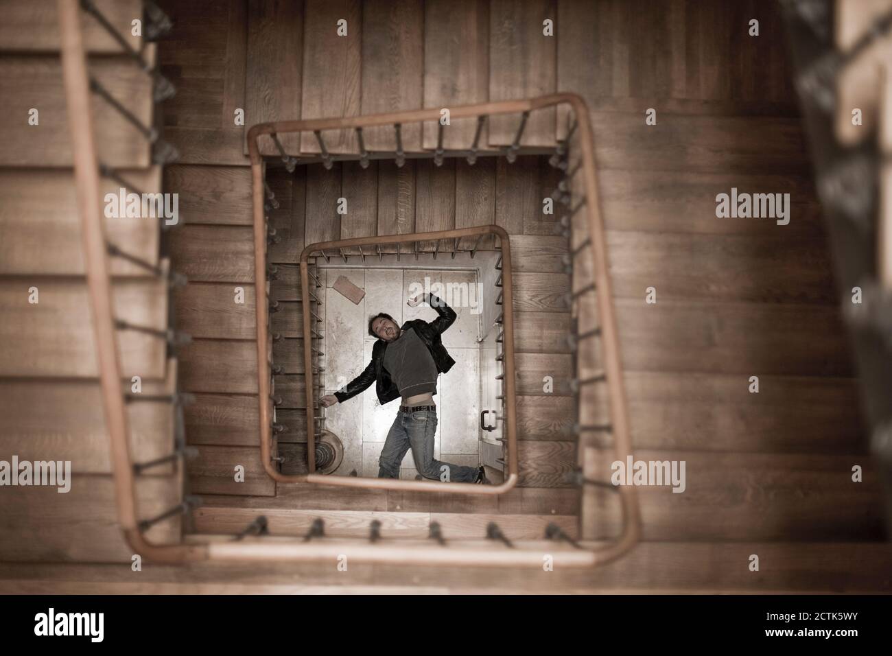 Directly above view of young man fallen down from staircase on floor ...