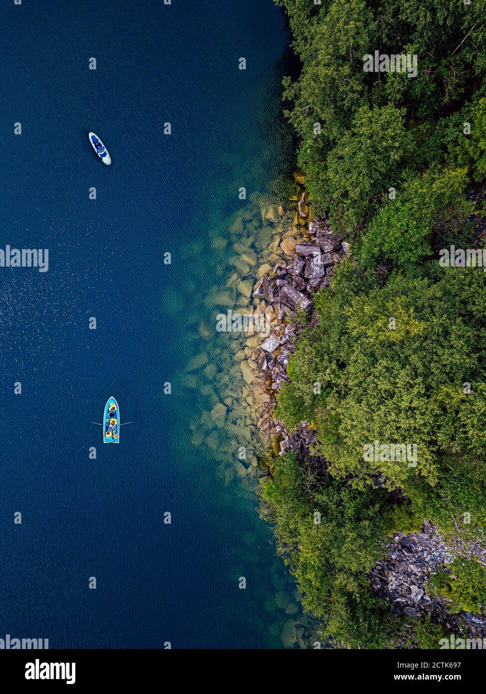 Aerial view of boat at rocky shore of Lake Light Stock Photo - Alamy