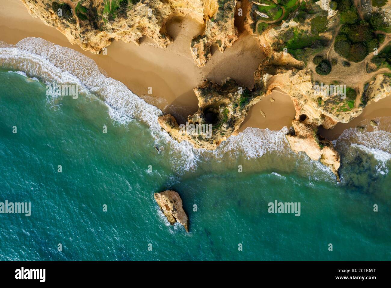 Portugal, Algarve, Alvor, Drone view of sandstone cliffs and beach at ...