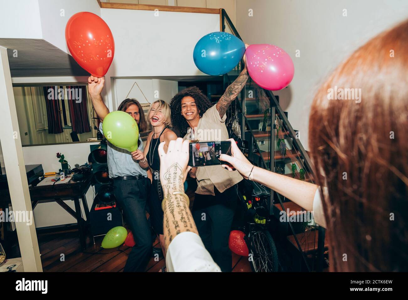 Woman photographing friends dancing during party at home Stock Photo ...