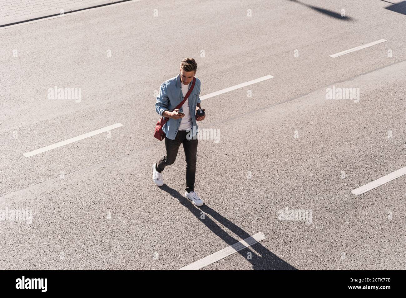 Using mobile crossing road hi-res stock photography and images - Alamy