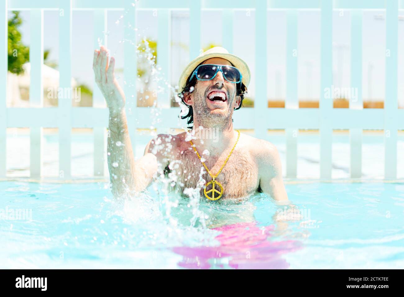 Happy man splashing water in swimming pool Stock Photo - Alamy