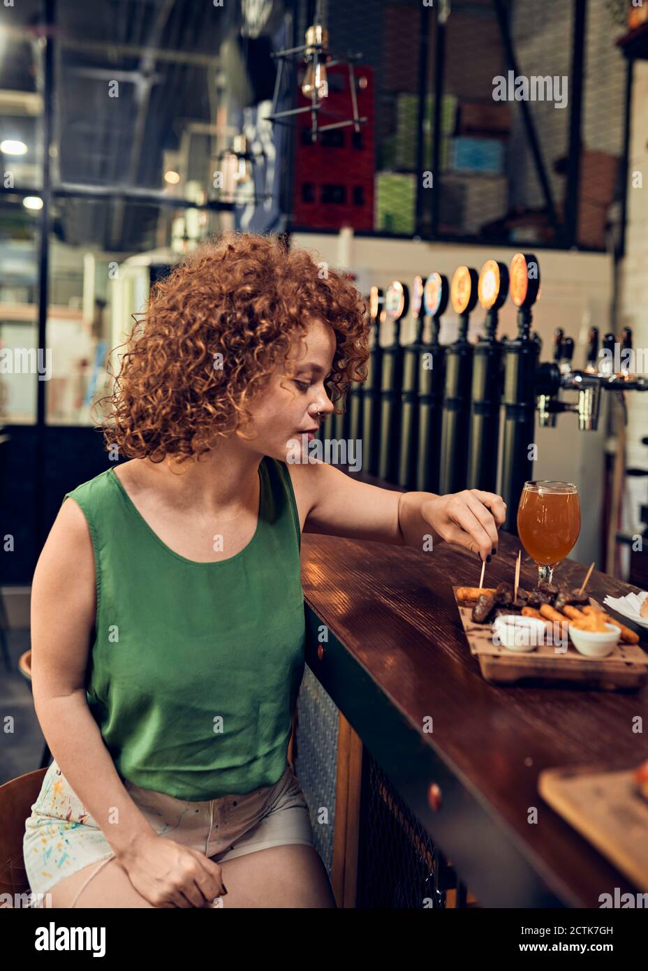 Woman having tapas at the counter in a pub Stock Photo - Alamy