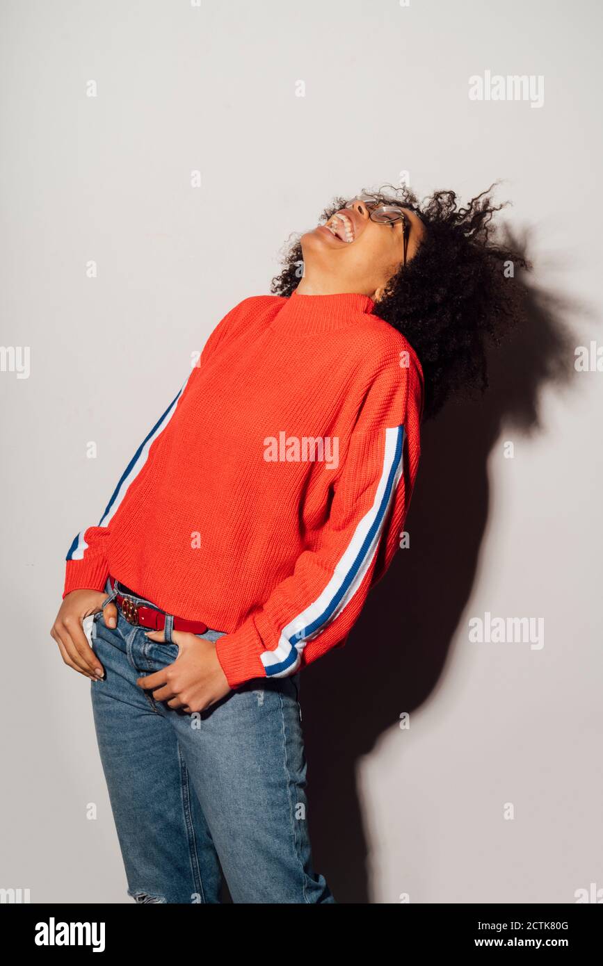 Young Woman laughing while standing against white background Stock ...
