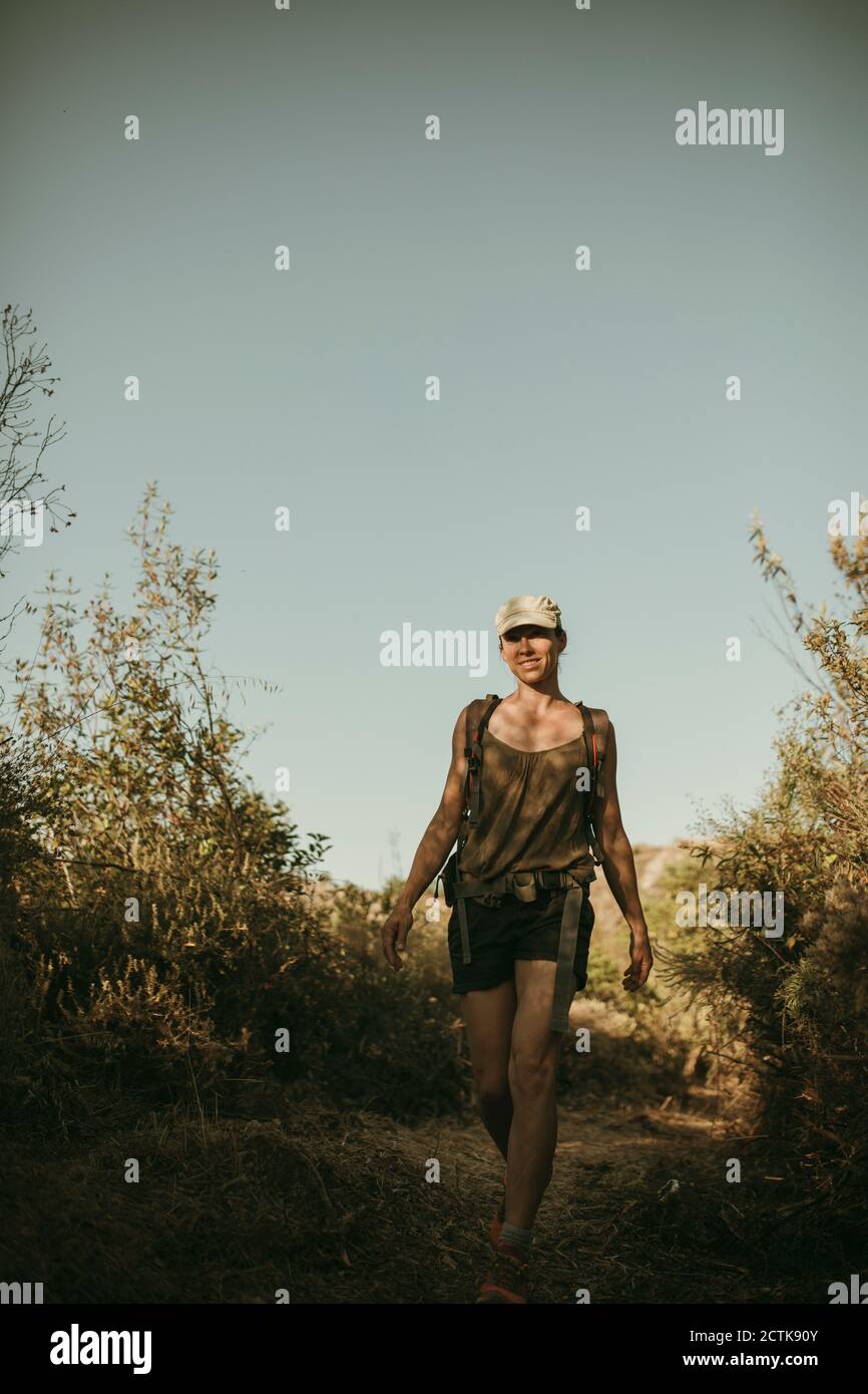 Woman explorer walking against sky in forest Stock Photo - Alamy