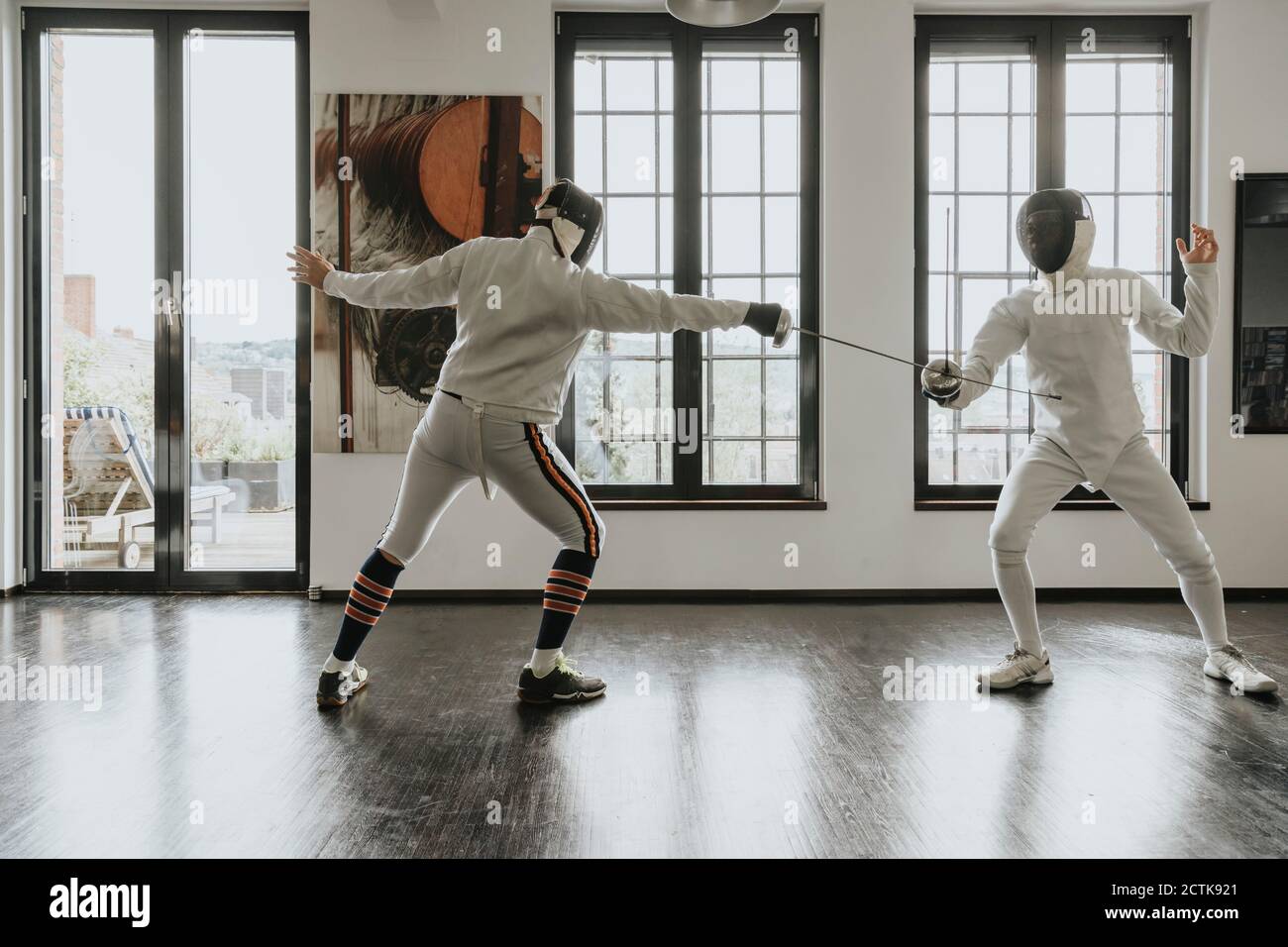 Fencers practicing fencing in loft Stock Photo - Alamy