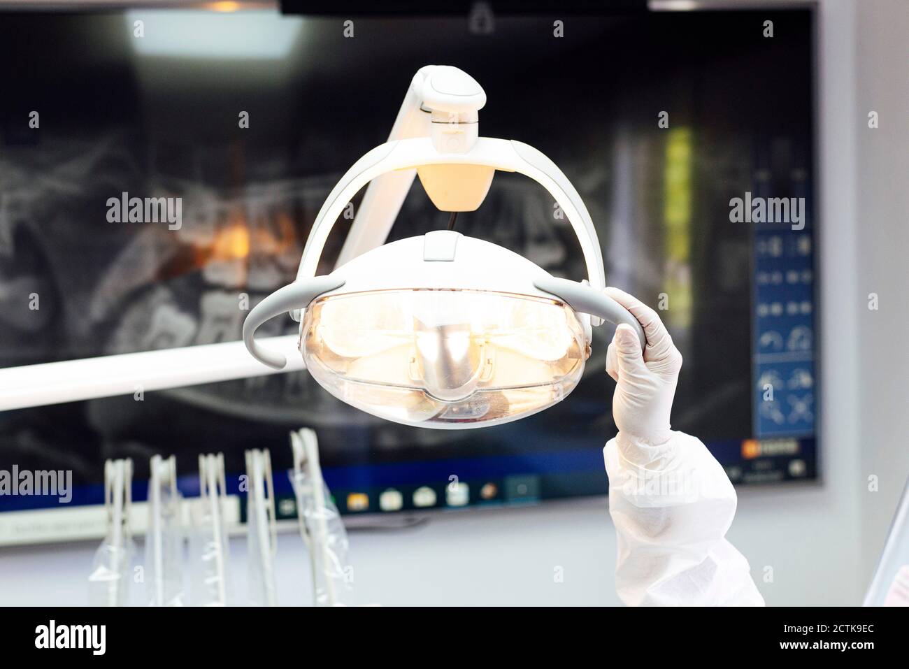 Doctor's hand adjusting illuminated electric lamp at clinic Stock Photo ...