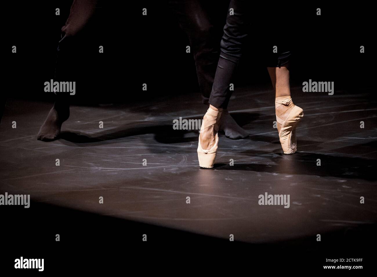 Close up of dancers dancing en pointe on black stage Stock Photo - Alamy