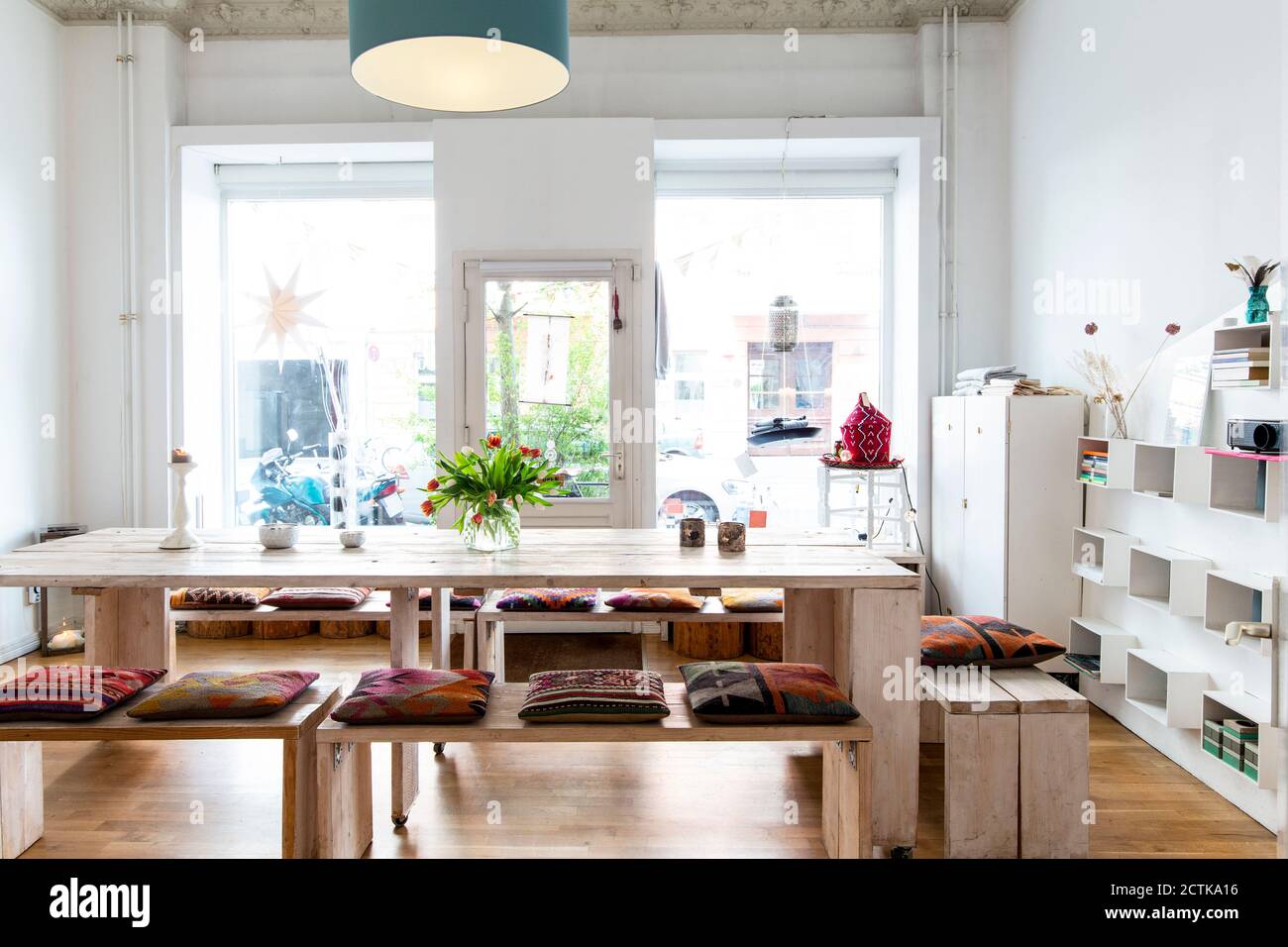 Dining table in bright room with large windows Stock Photo - Alamy