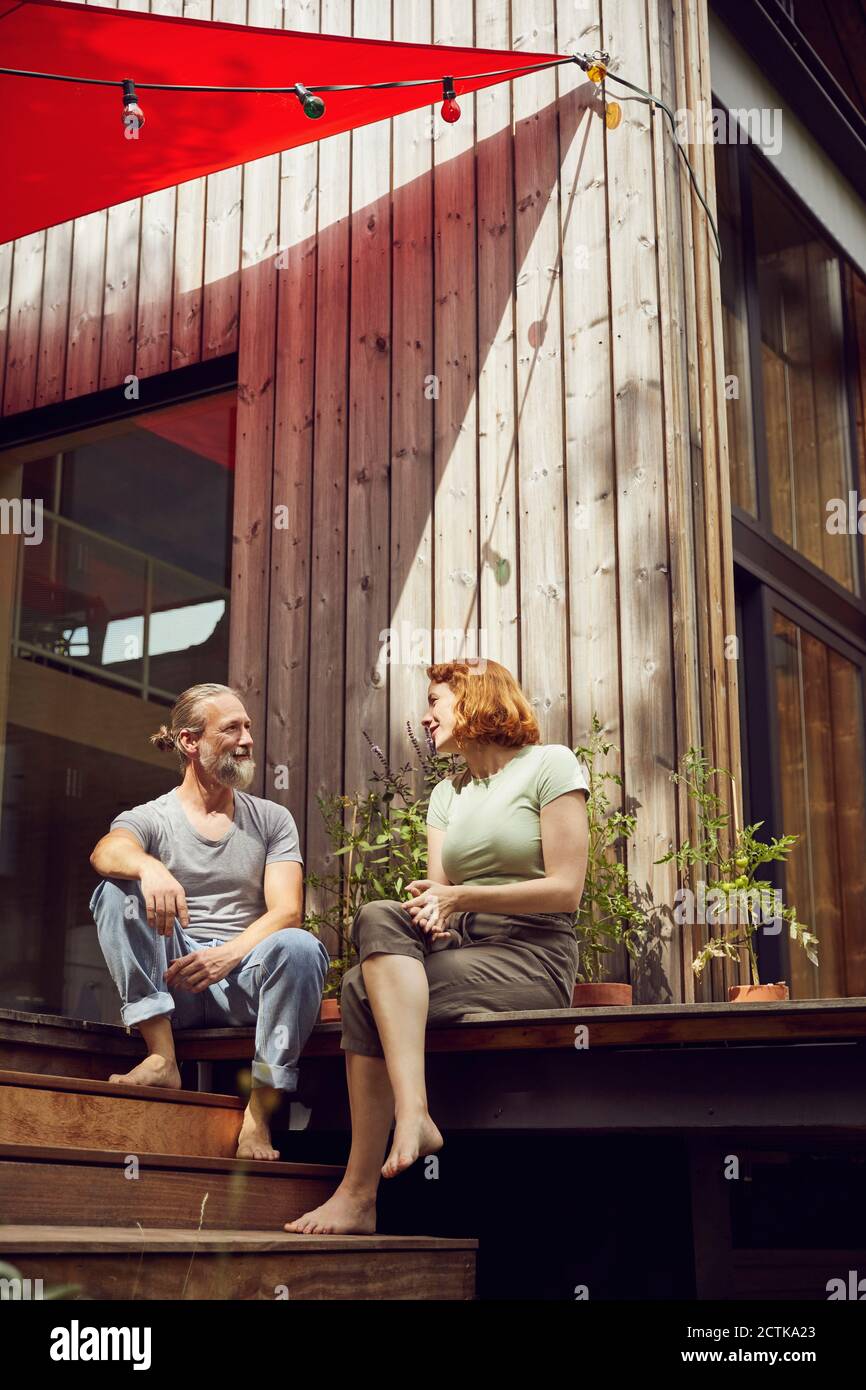 Couple talking while sitting outside tiny house Stock Photo - Alamy