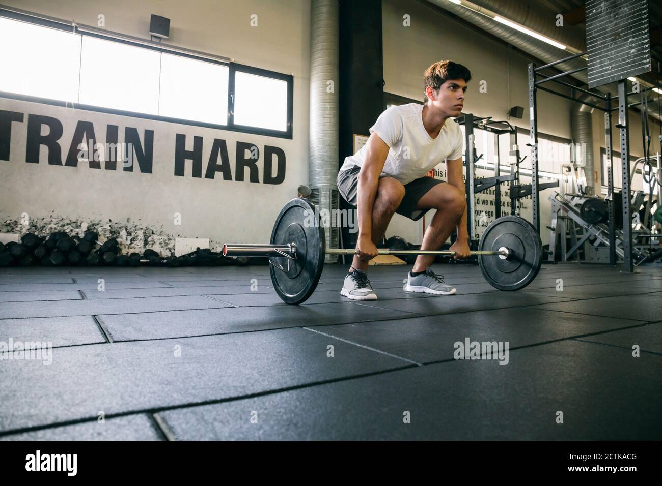 Male athlete lifting deadlift while exercising in gym Stock Photo - Alamy