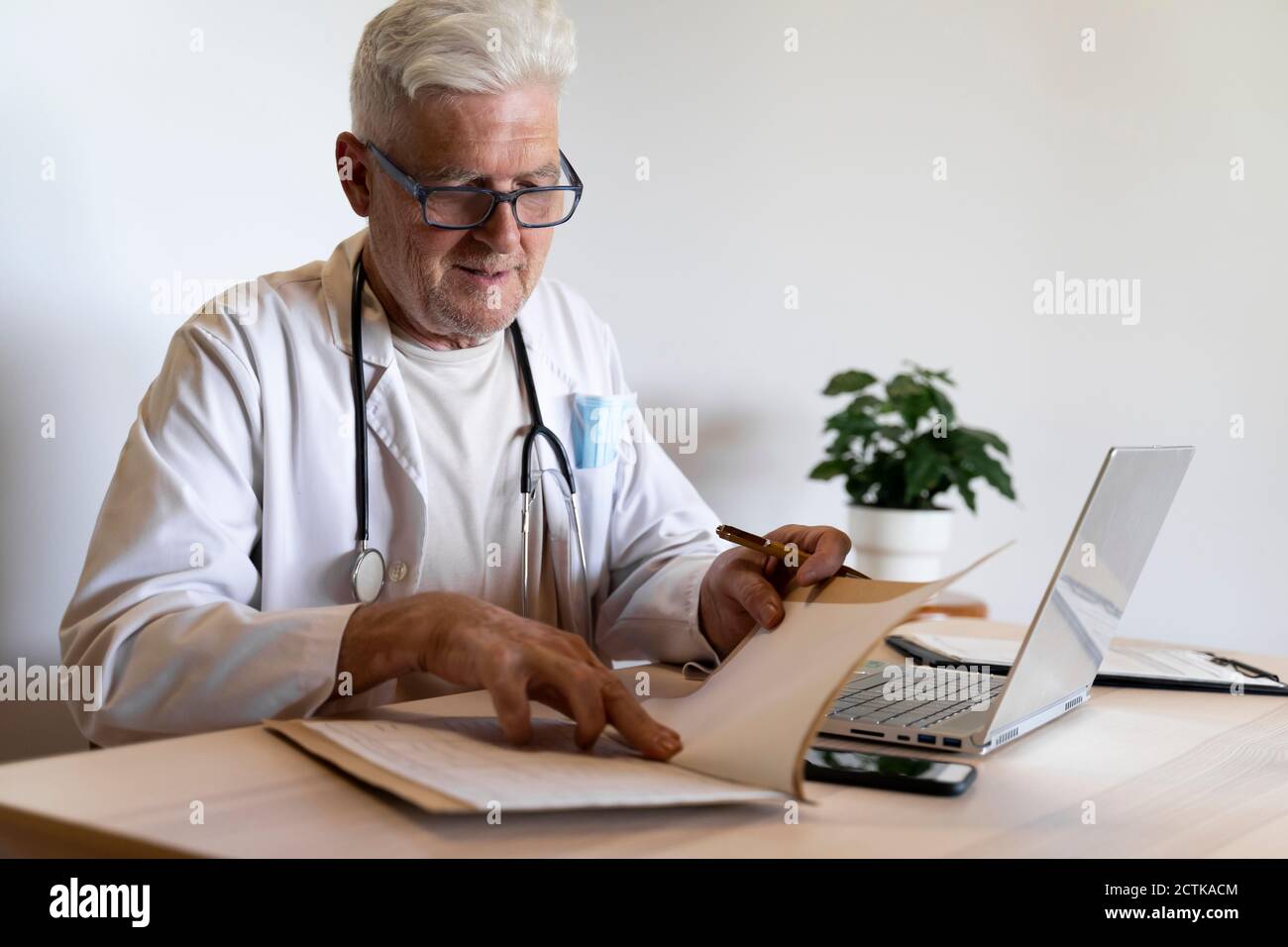 Doctor sitting senior hospital hi-res stock photography and images - Alamy