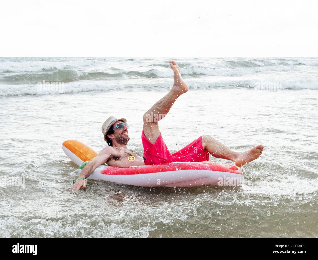 Happy man bathing in the sea on inflatable float Stock Photo - Alamy