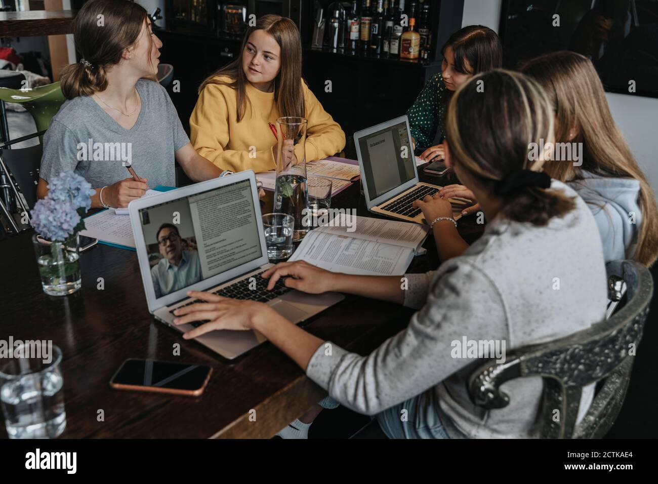 Teenage girls studying and learning from home, using laptops Stock ...