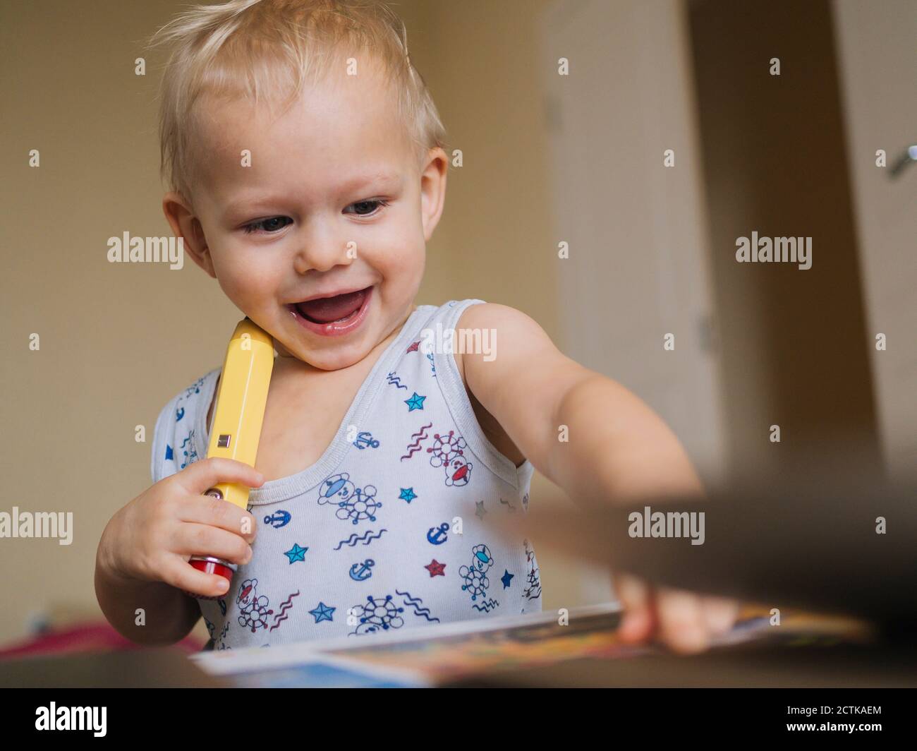 Cute happy baby playing with pencil at home Stock Photo - Alamy