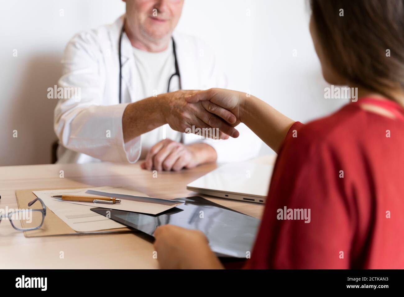 Doctor shaking hand with patient in clinic Stock Photo - Alamy