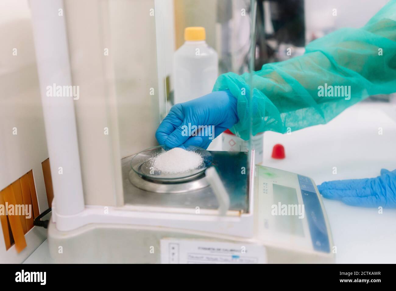 Hands of female scientist measuring powder medicine on scale in ...