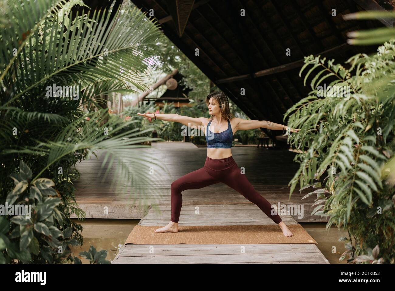 Woman practicing warrior pose Stock Photo - Alamy