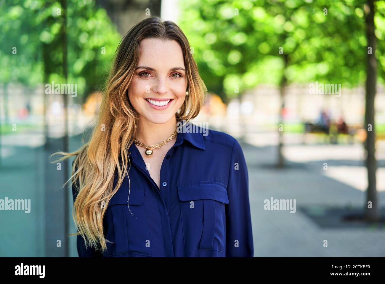 Beautiful woman smiling while standing outdoors Stock Photo - Alamy