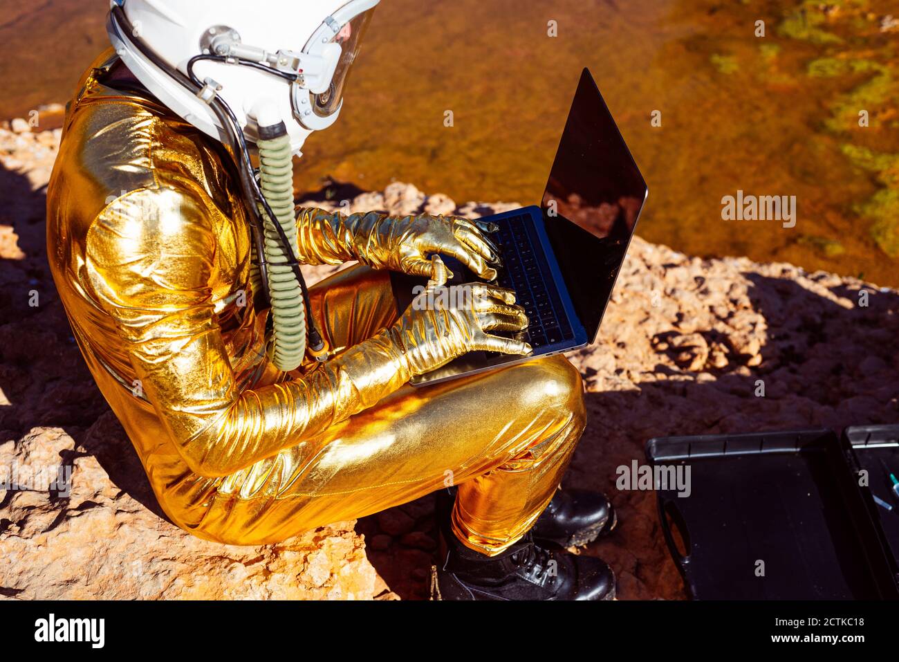 Astronaut using laptop while sitting on moon Stock Photo - Alamy