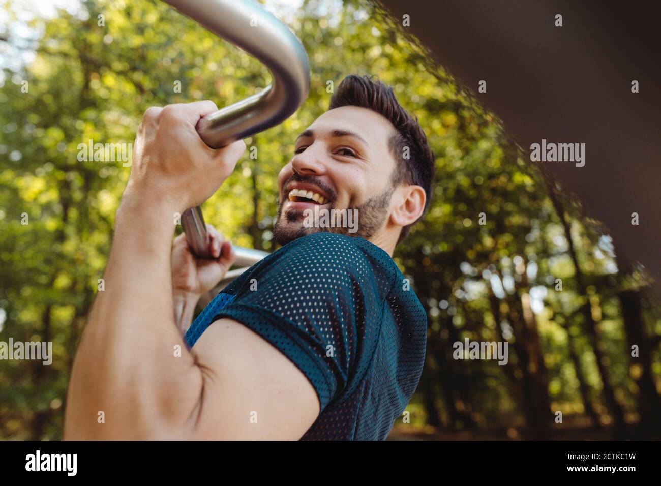 Happy man lifting himself up on a fitness trail Stock Photo - Alamy