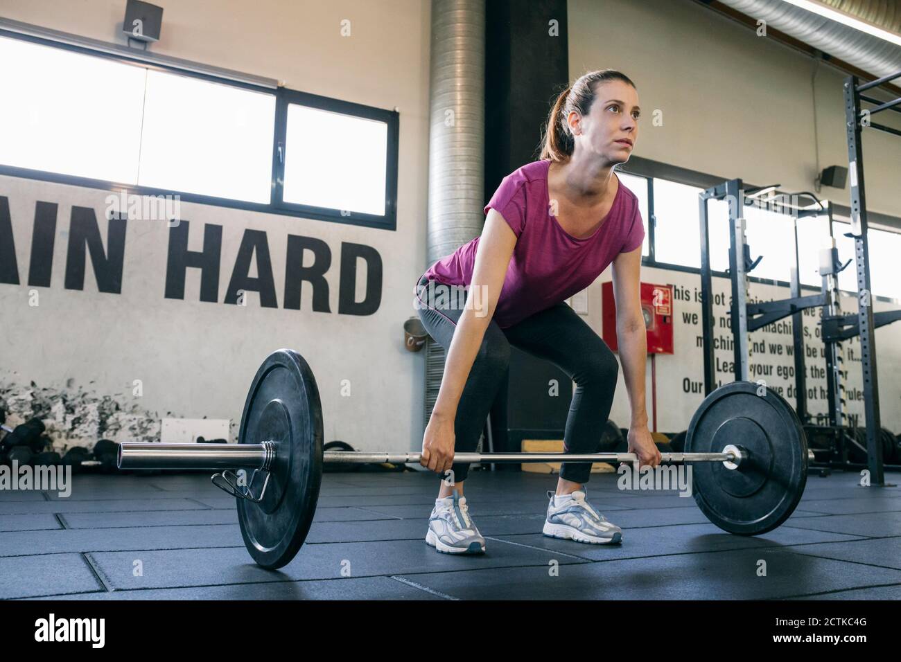 Female athlete lifting deadlift while standing in gym Stock Photo - Alamy
